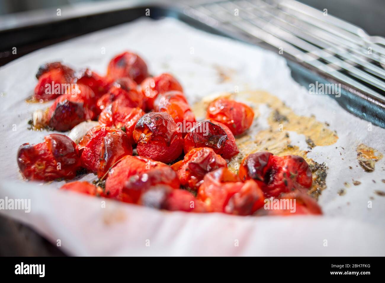 A batch of cherry tomatoes with charred skins after being cooked ...