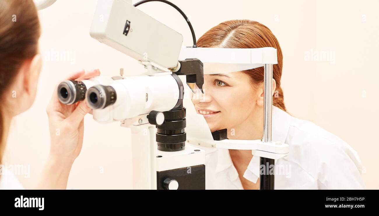 ophthalmologist doctor in exam optician laboratory with female patient ...
