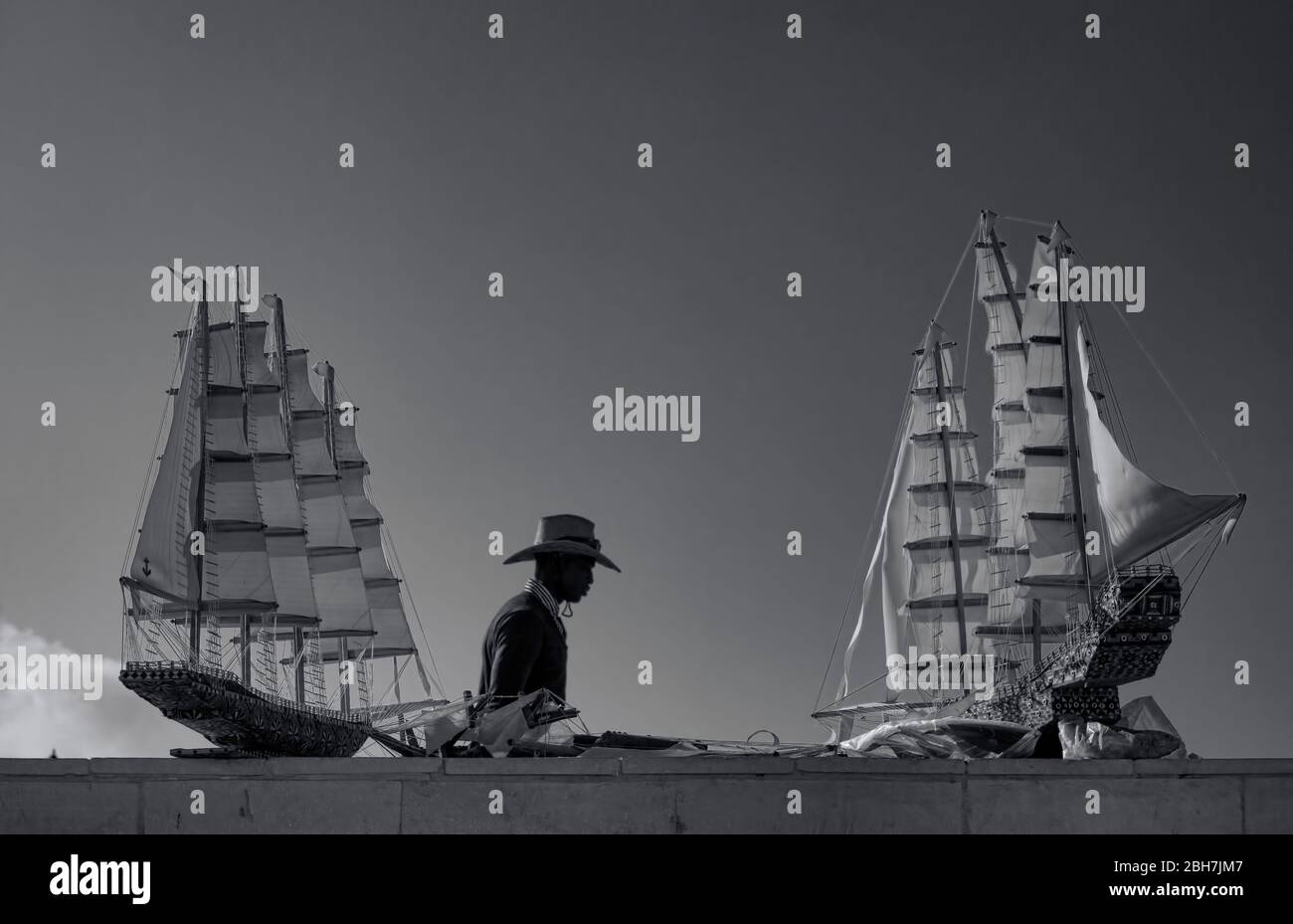 Black and white photo of man standing behind ships. Monochromatic photo ...
