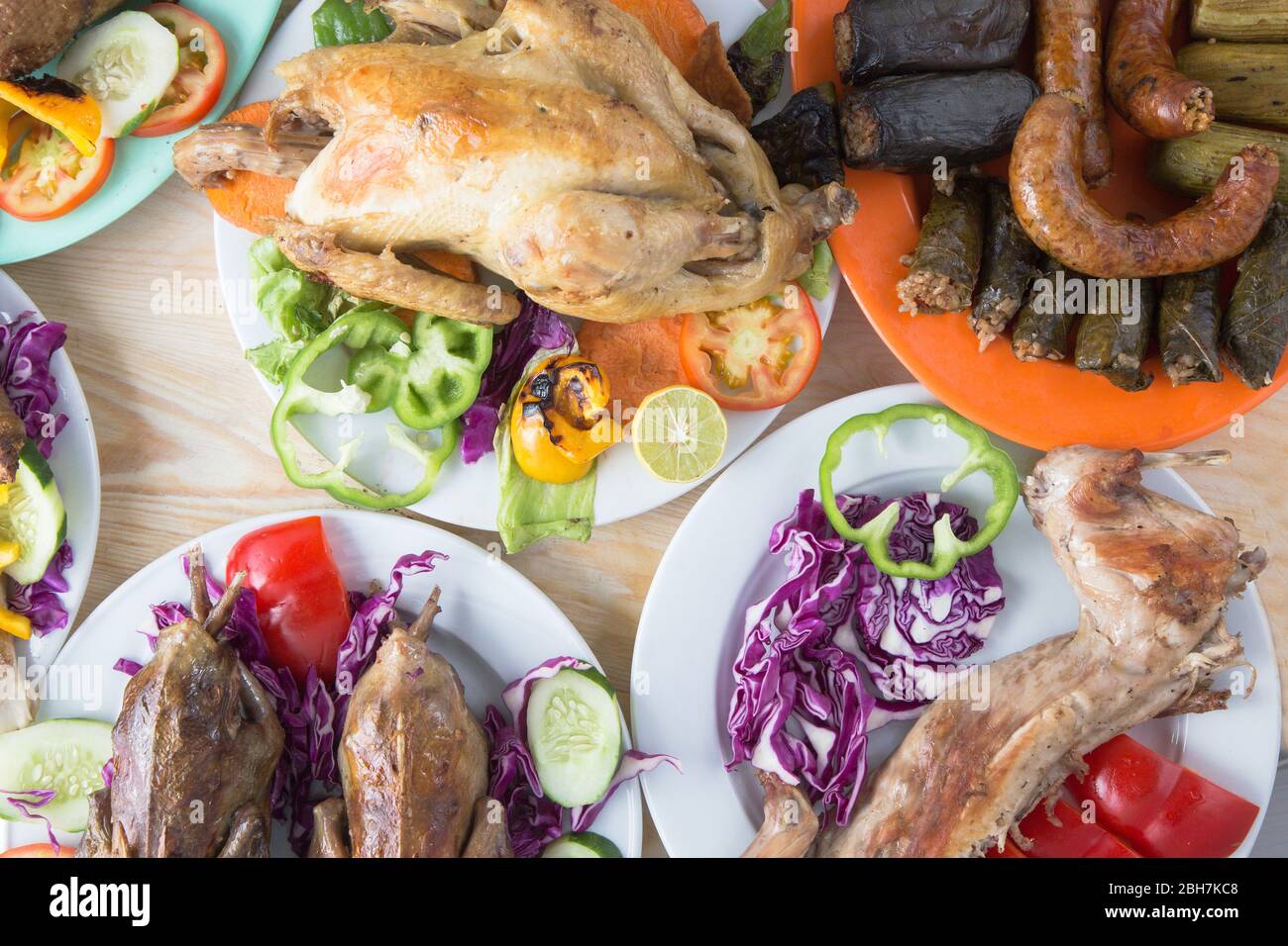 Wooden table with various meat dishes with vegetables. Top view of ...
