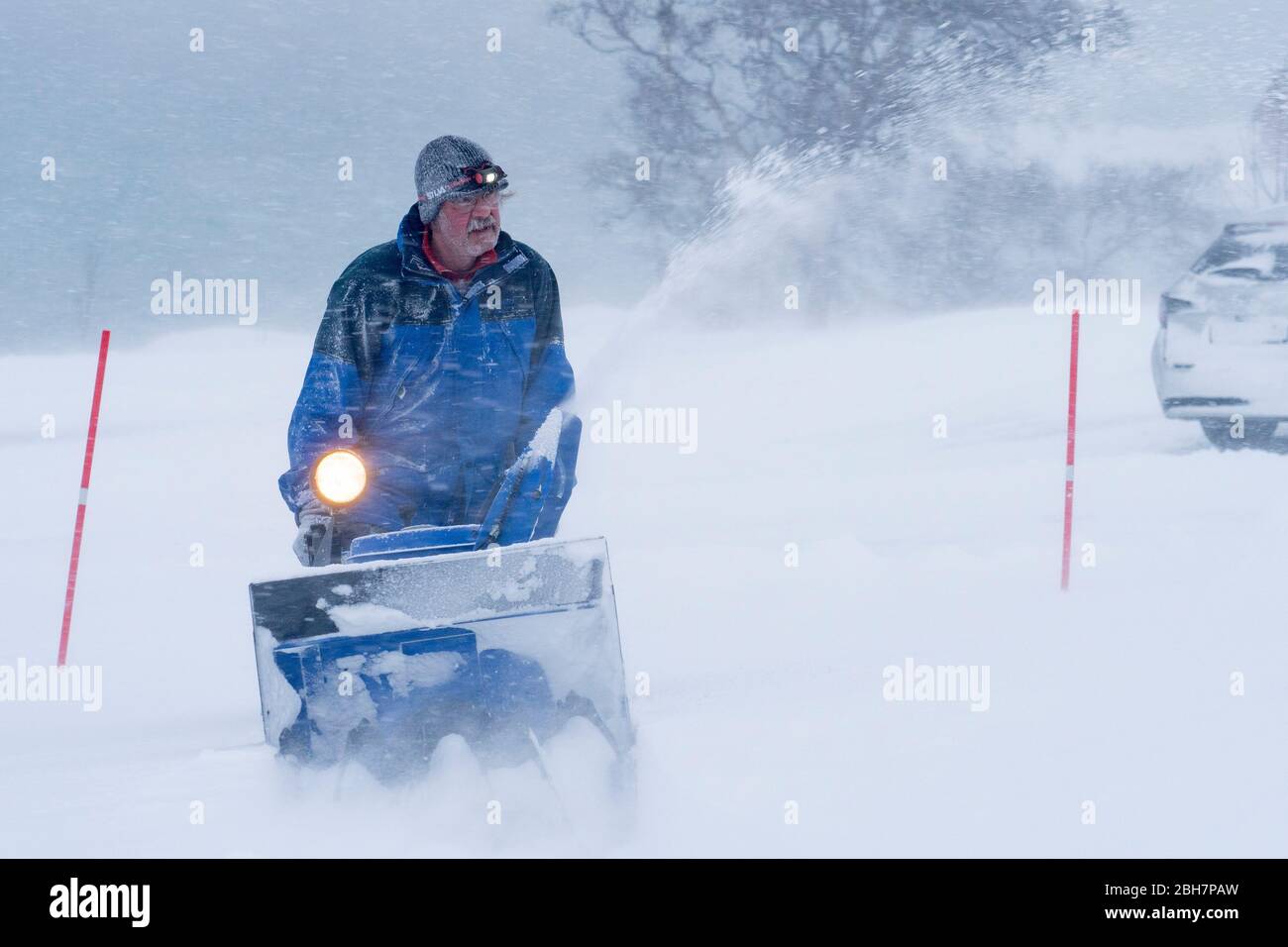 facility manager riding a snowblower in a heavy blizzard in northern ...