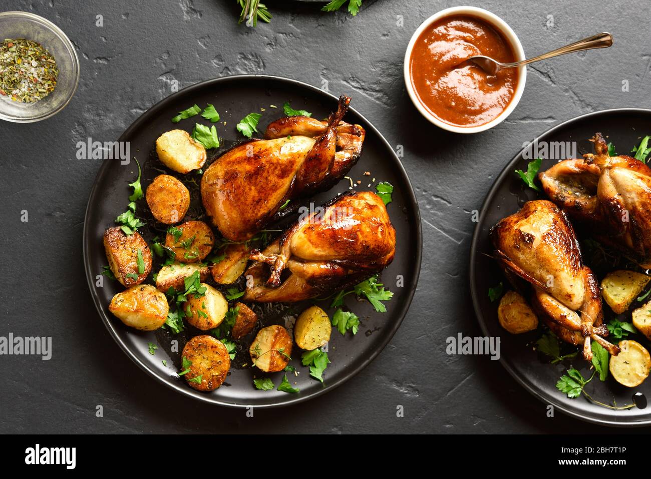 Tasty grilled quails carcasses on black stone background. Roasted ...