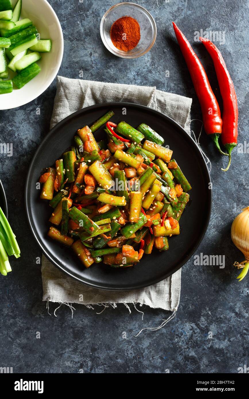 Korean style cucumber kimchi on plate over stone background. Top view ...