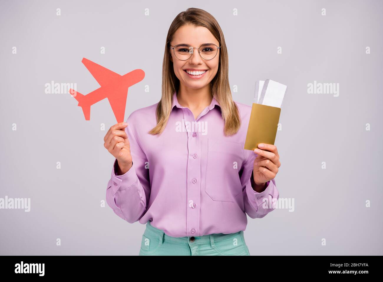 Portrait of positive cheerful girl hold paper card plane ready travel ...