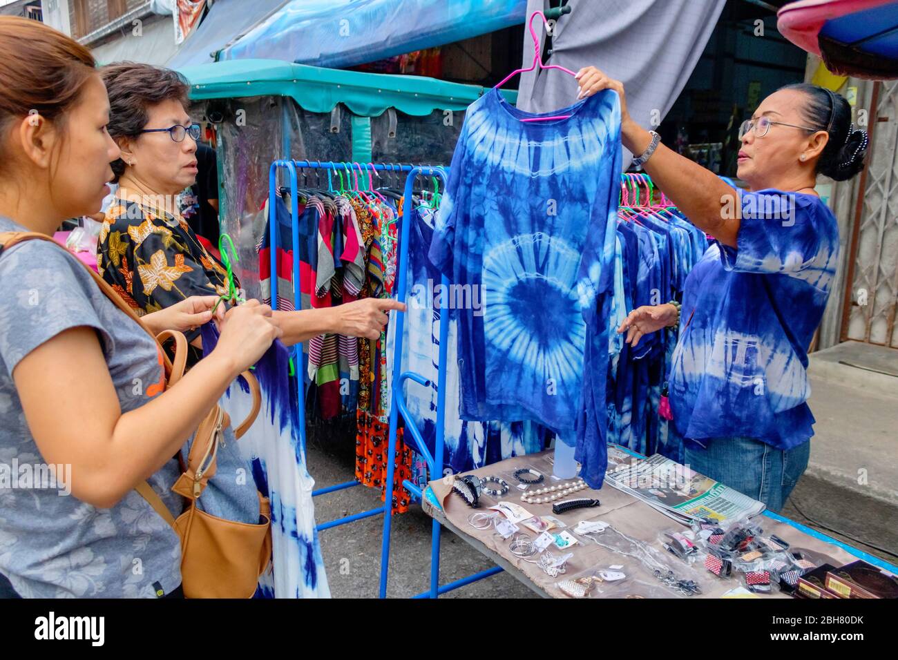 The two customers are buying an indigo dyed shirt from a vendor in ...