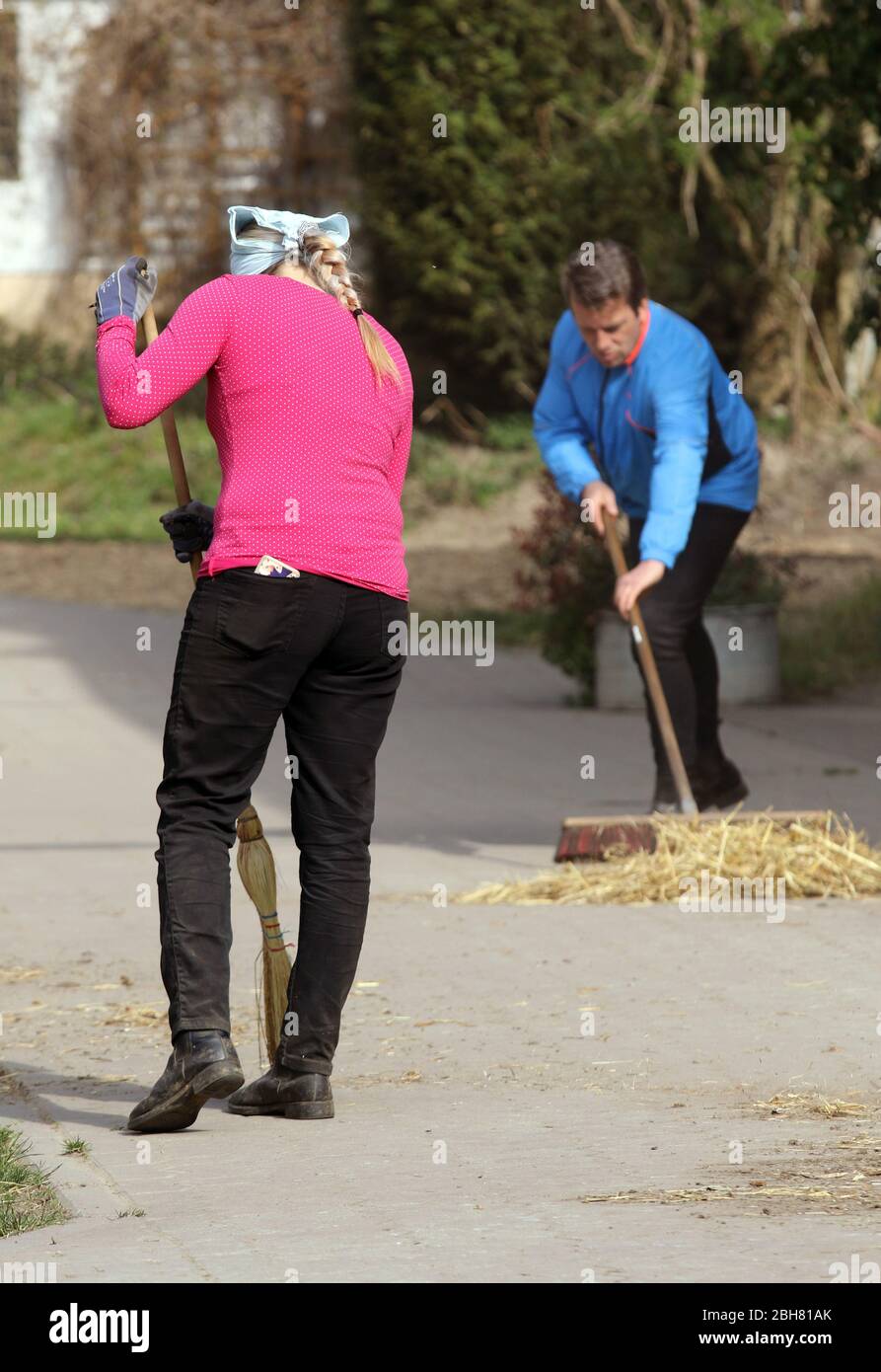 09.04.2020, Neuenhagen, Brandenburg, Germany - Stable employee sweeping ...