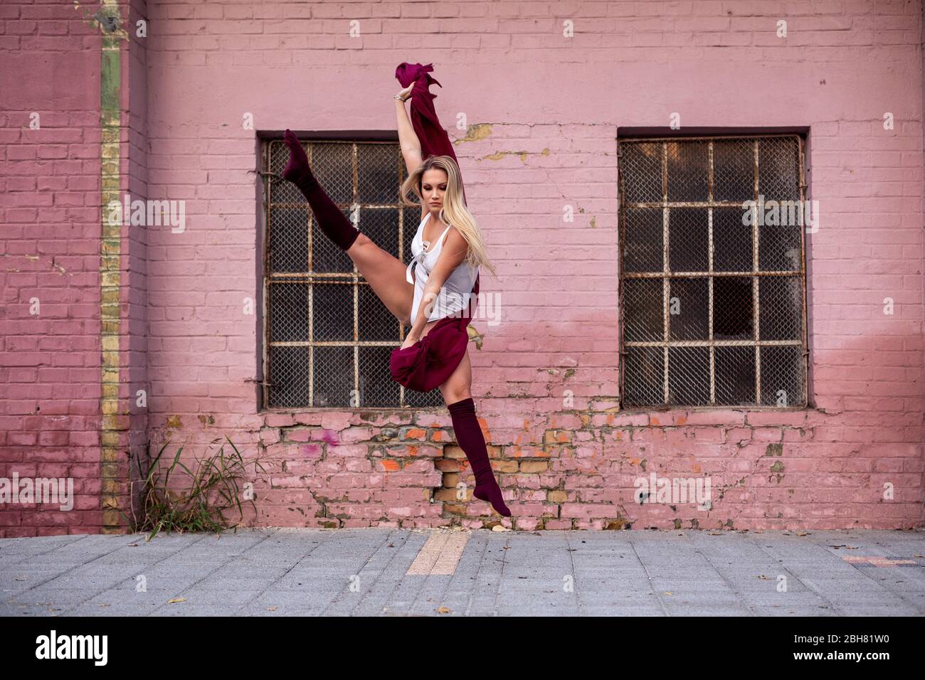 Ballet dancer girl jump on street in front of pink wall Stock Photo - Alamy