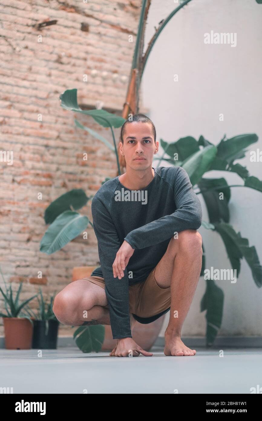 Exotic caucasian young man with a grey jersey and brown shorts looking ...