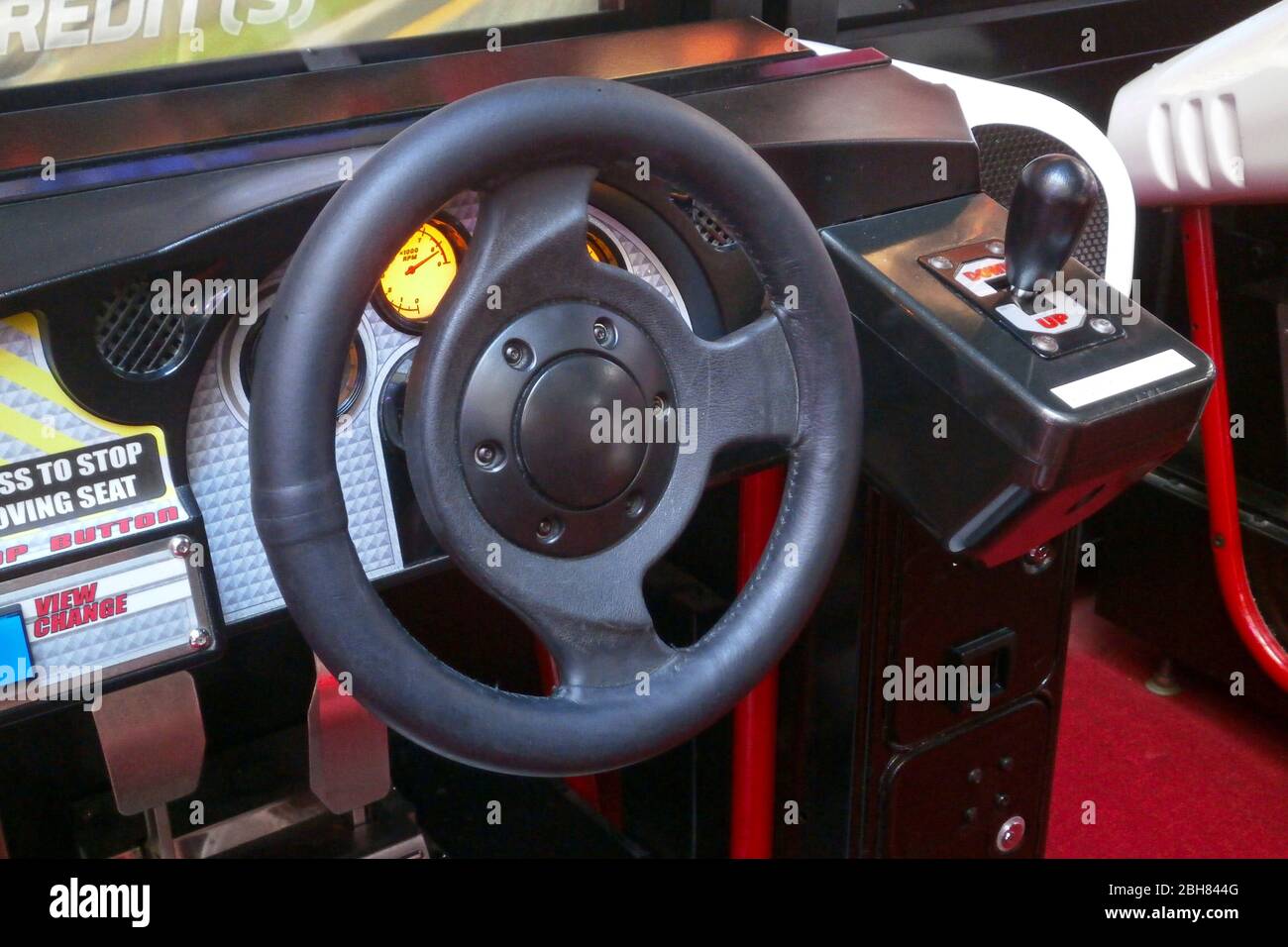 Close-up on a wheel of a racing simulator game in an arcade with all ...