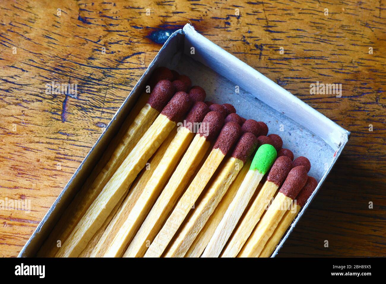 Matchbox of brown matches with a green one Stock Photo - Alamy