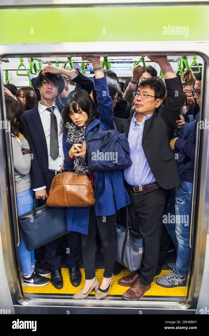 Commuters squeezing on to yamonote line rush hour train hi-res stock ...