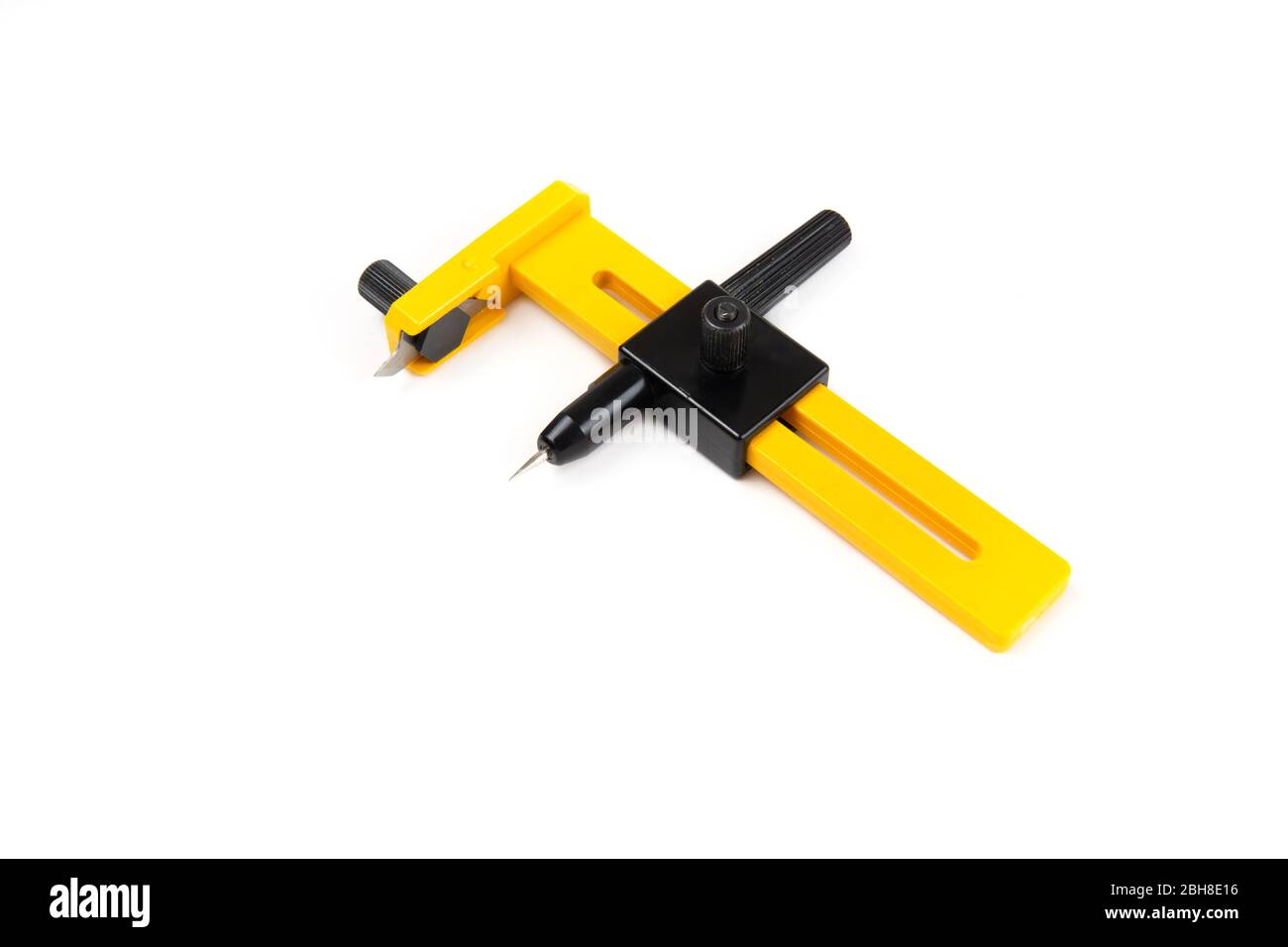 Yellow rotary compass cutter isolated on white. Closeup shot, top side ...