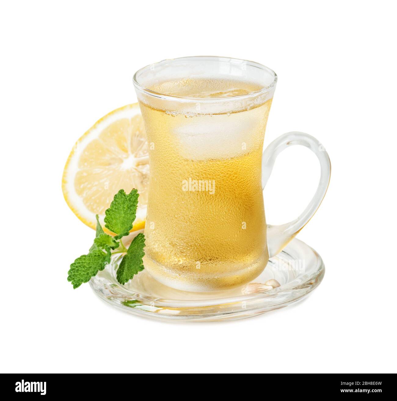Misted glass cup of cold green tea with ice, yellow lemon and green ...