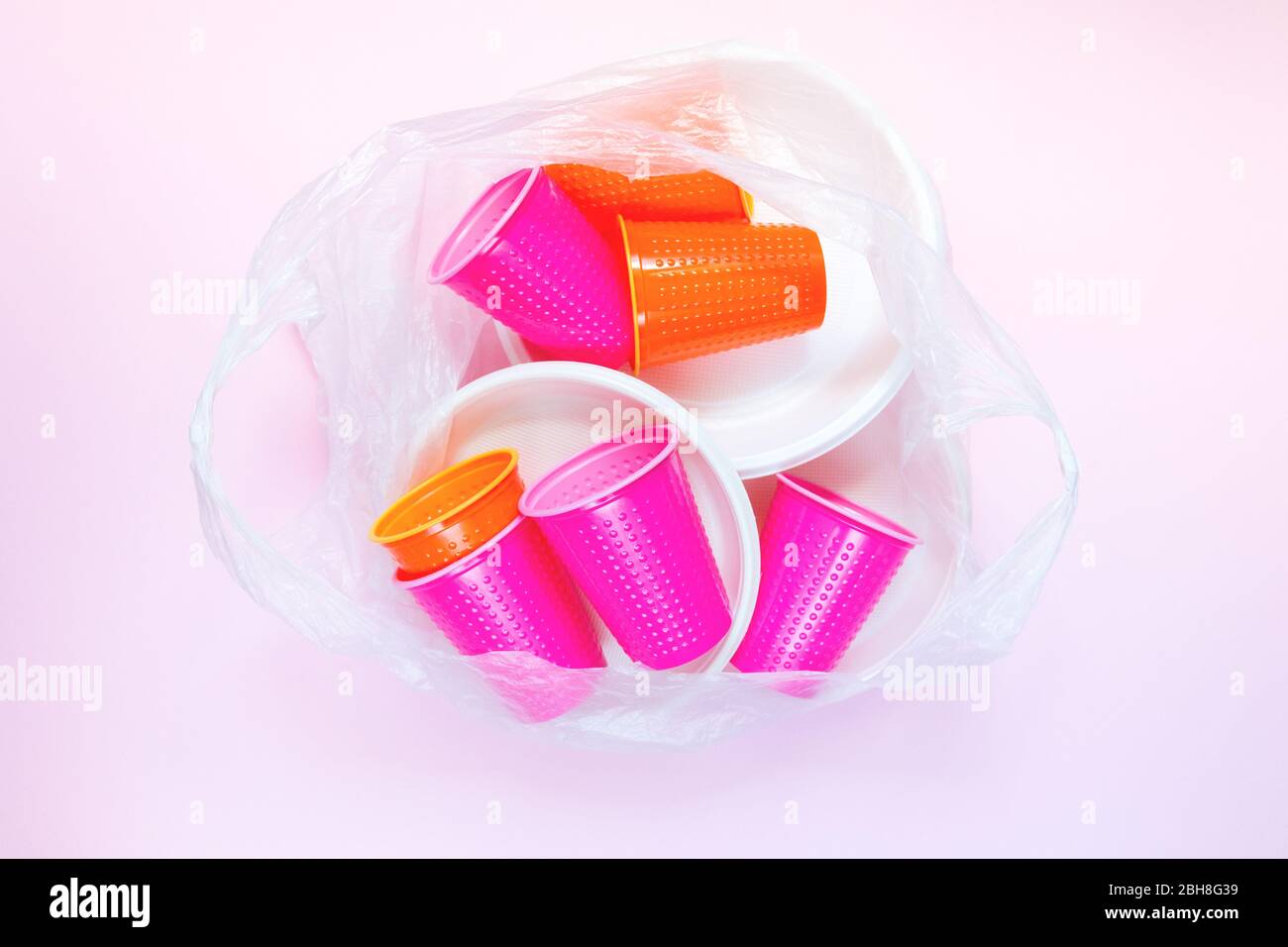 Plastic waste in a bag on a pink background. Concept of plastic ...