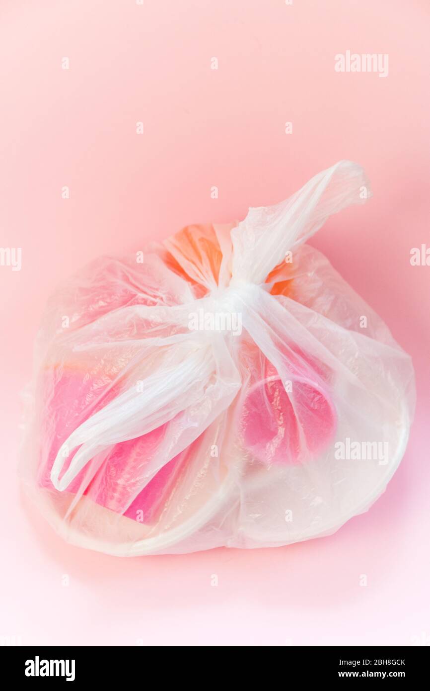 Plastic waste in a bag on a pink background. Concept of plastic ...