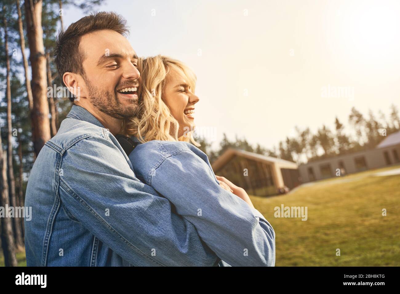 Man putting his arms around his girlfriend Stock Photo - Alamy