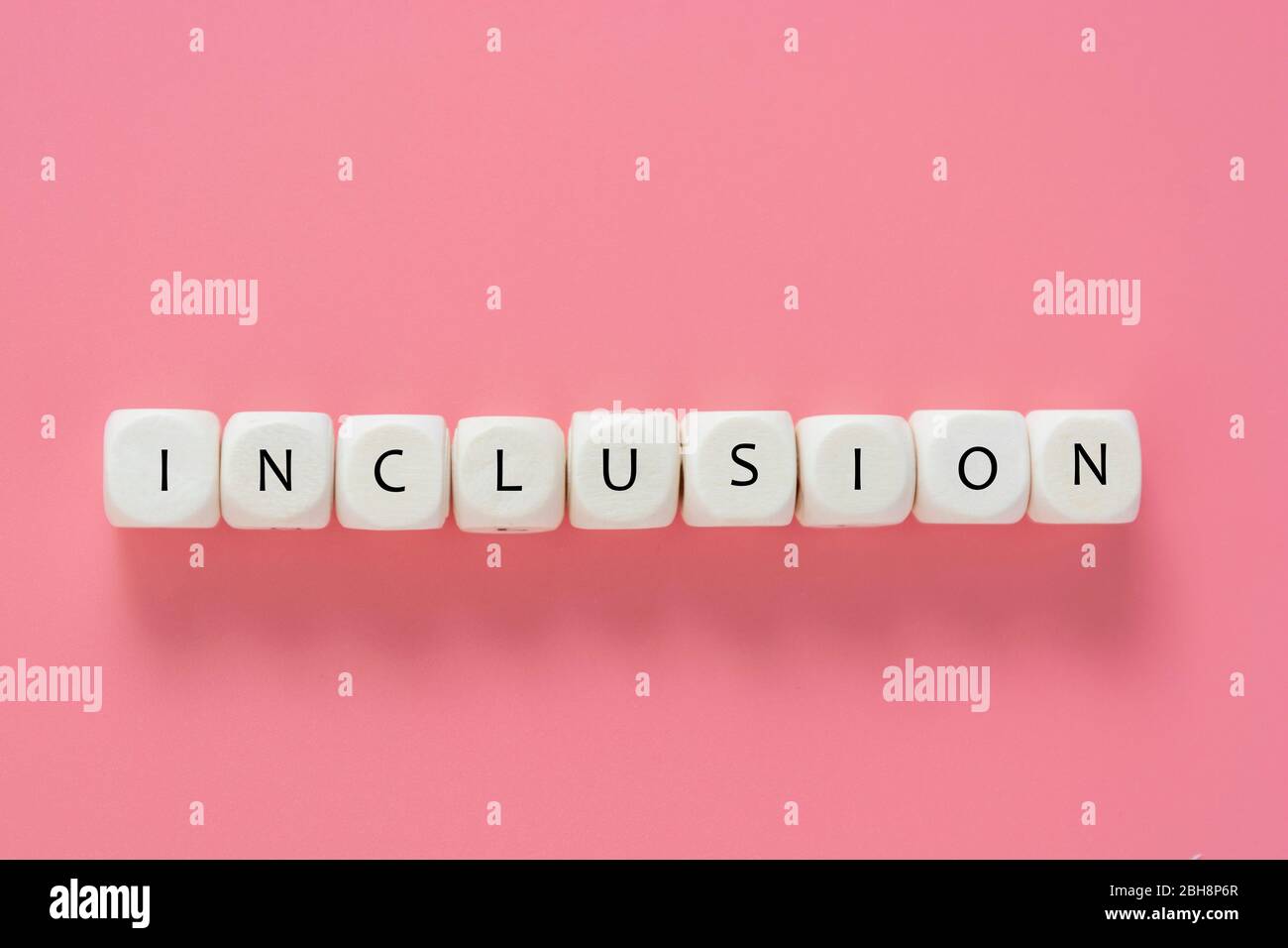 Inclusion text made from wooden cubes on pink background. Inclusive ...