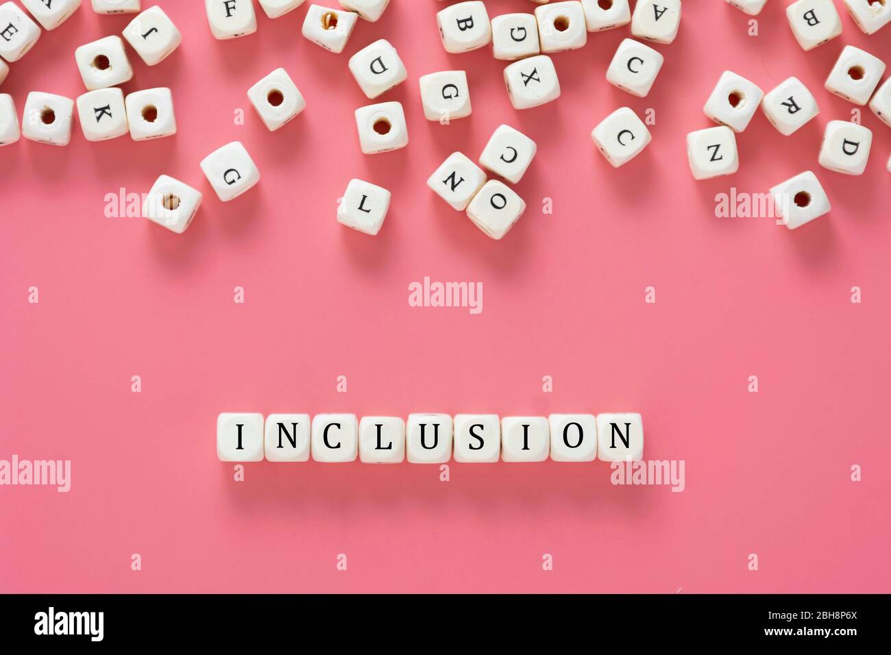 Inclusion text made from wooden cubes on pink background. Inclusive ...