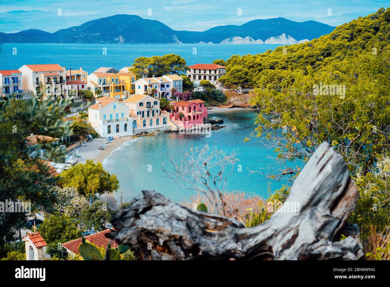 Assos village in Kefalonia, Greece. Calm blue bay water and colored ...