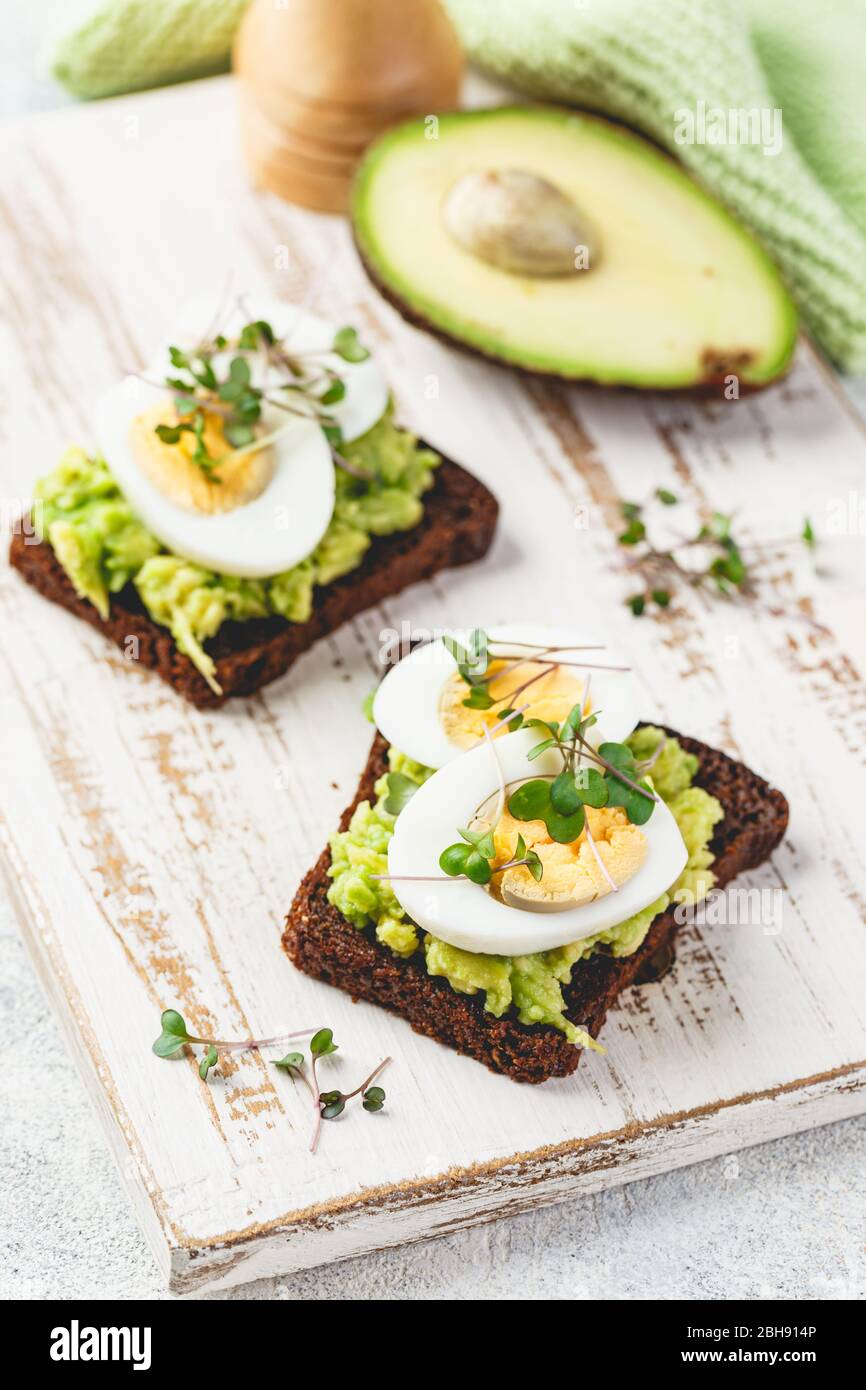 Healthy toast on rye bread with avocado, boiled eggs, spices and ...