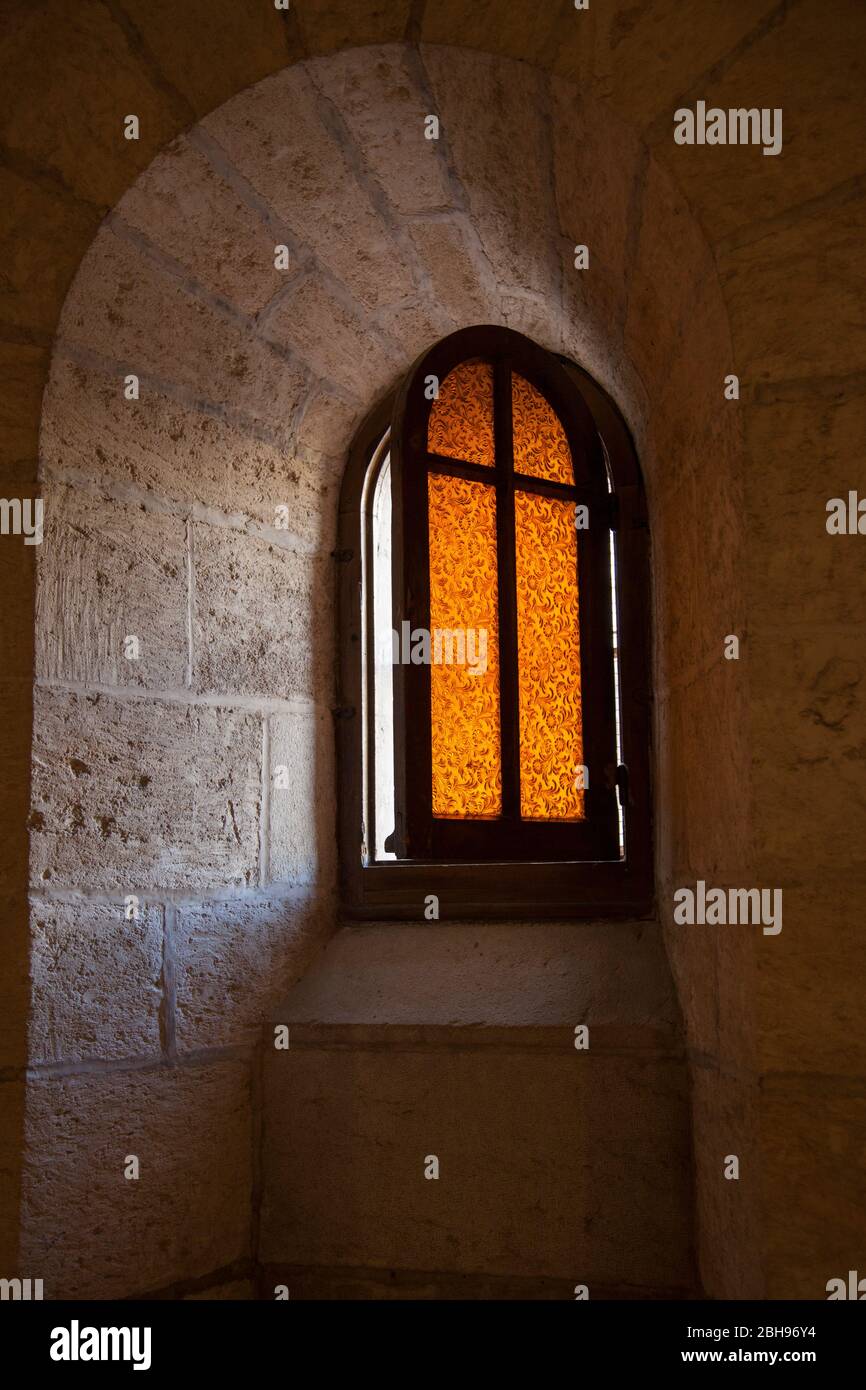 open orange glass window with cross rungs, light falls in, Israel ...