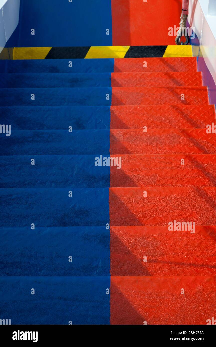 brightly colored metal stair steps on a ferry, color contrast red blue ...