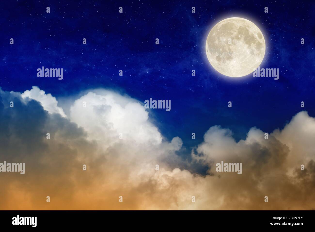 Full moon rising above glowing clouds in night sky. Elements of this ...