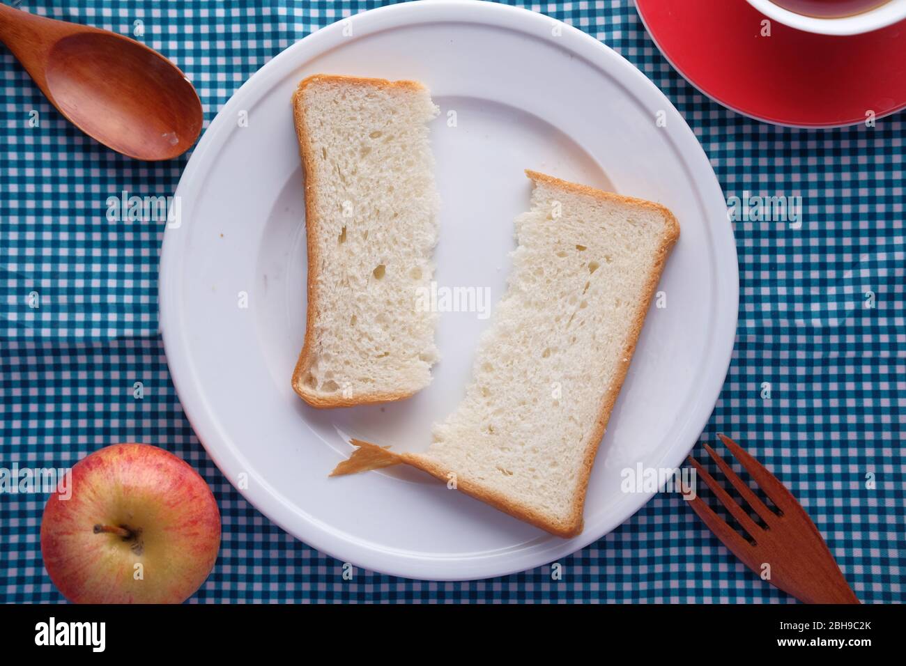 Half slice of bread in a plate on table Stock Photo - Alamy