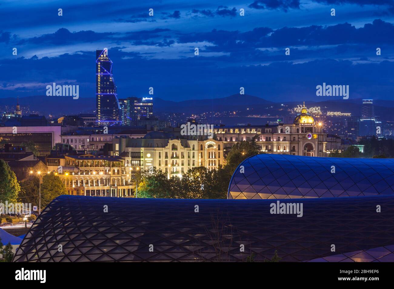 Georgia, Tbilisi, Concert Hall and Biltmore Hotel Tower, dusk Stock ...