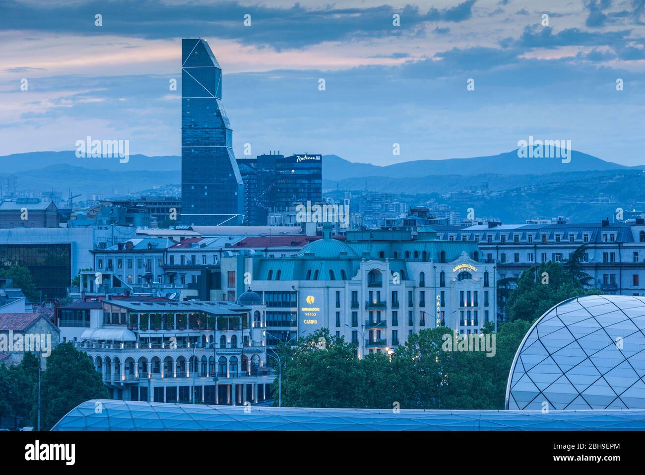 Georgia, Tbilisi, Concert Hall and Biltmore Hotel Tower, dusk Stock ...