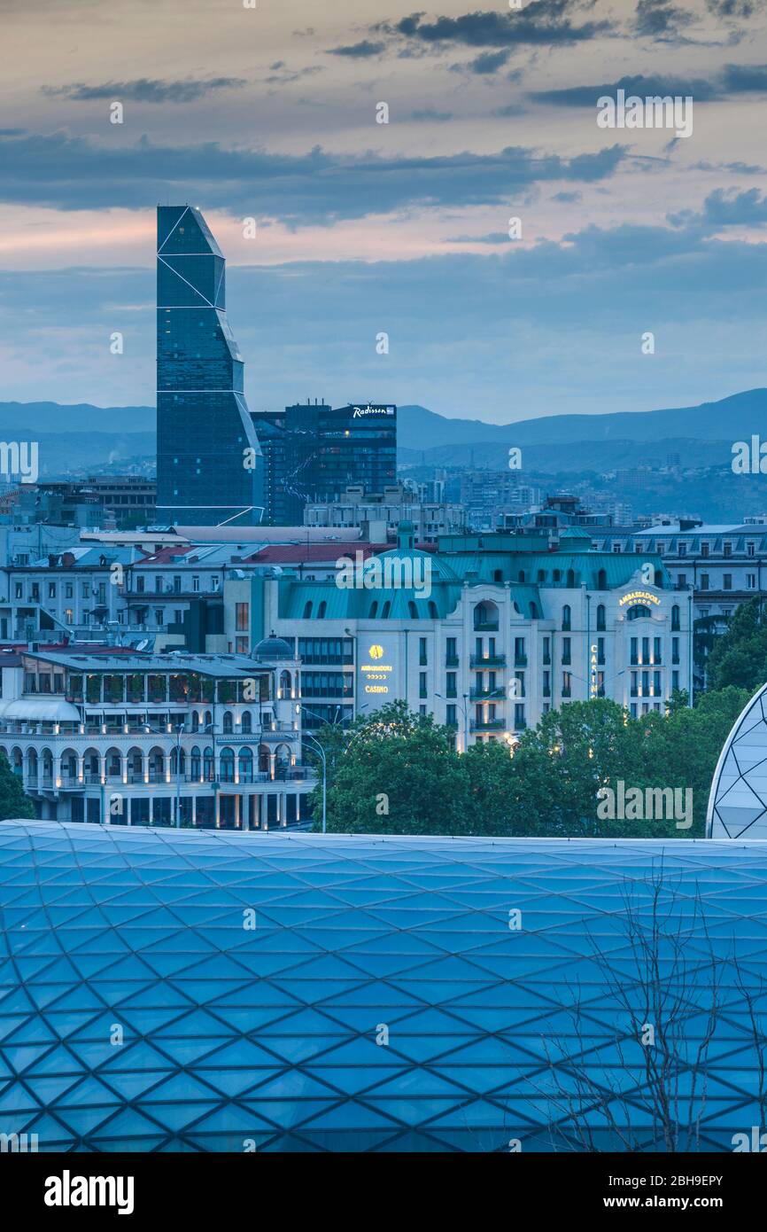 Georgia, Tbilisi, Concert Hall and Biltmore Hotel Tower, dusk Stock ...