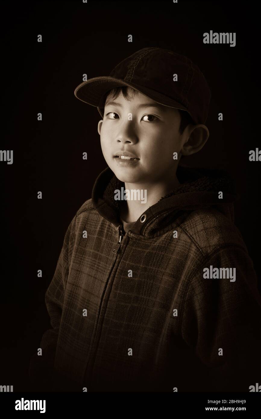 Cute Asian Chinese boy posing in hoodie sweater and baseball cap in ...