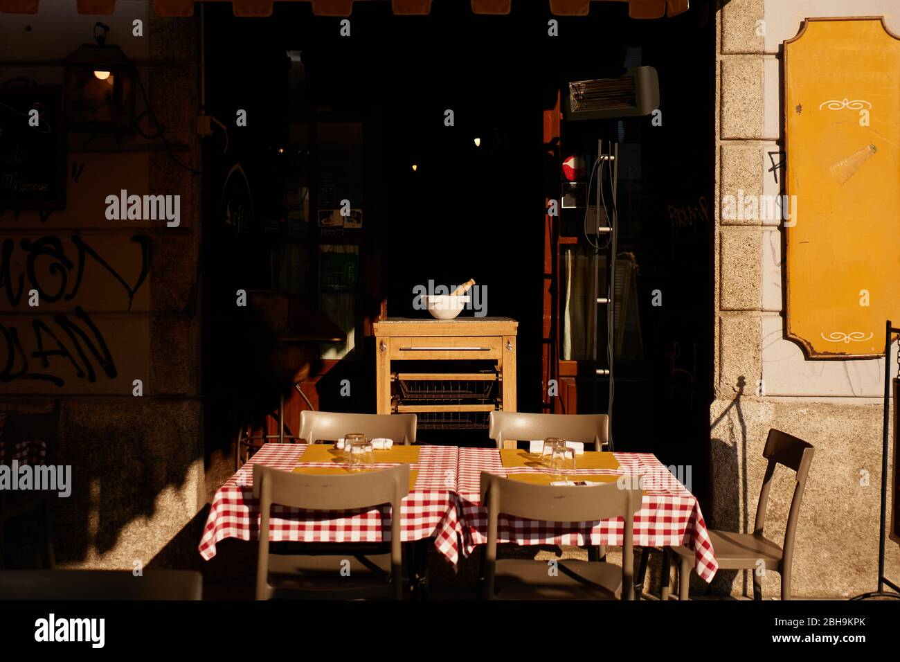 Classical outdoor street cafe in Milan, Italy. Table with old chairs on ...