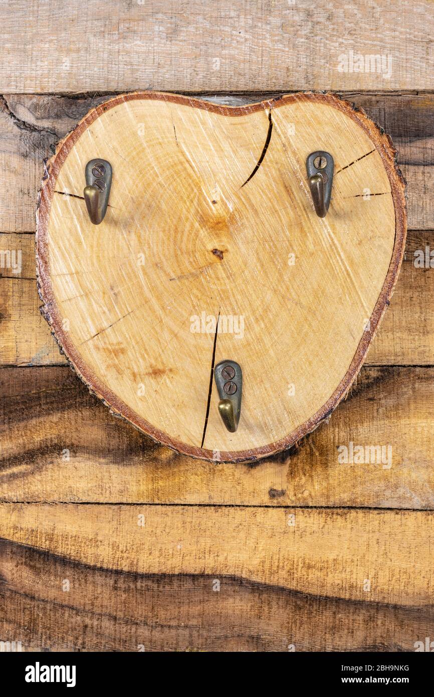 Wooden disc in heart shape with hooks Stock Photo - Alamy