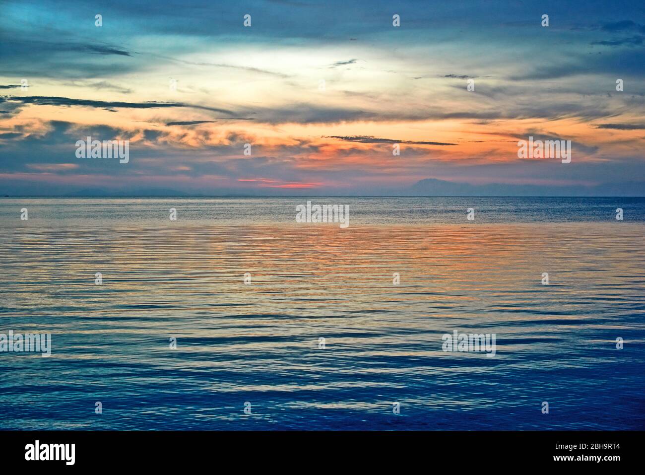 Sunset over water Stock Photo - Alamy