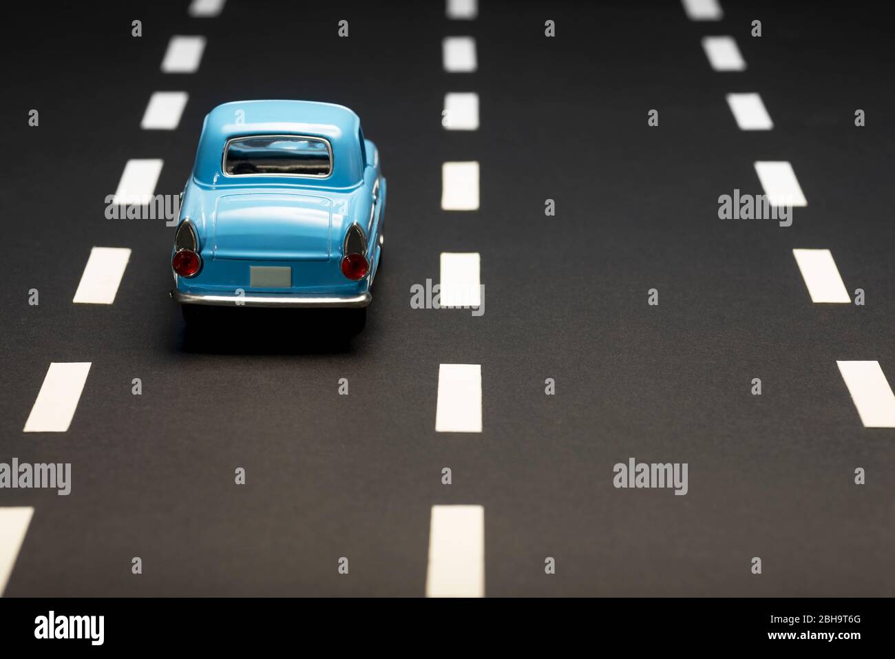 Rear view of a blue toy car on an asphalt road Stock Photo - Alamy