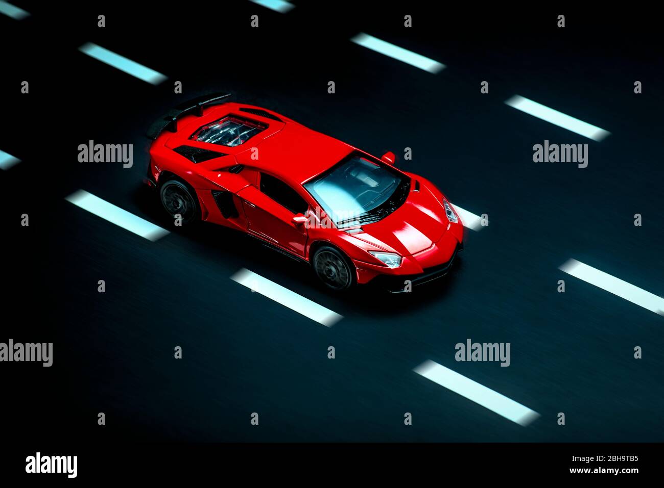 Red sports car on an asphalt road with road lanes Stock Photo - Alamy
