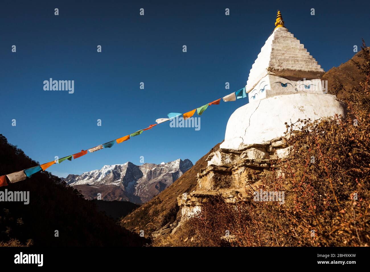 Temple with prayer banner, mountains in the background Stock Photo - Alamy
