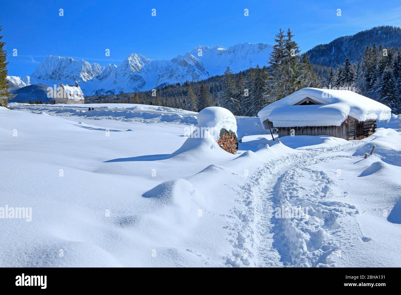 Winterly snowy huts with Karwendel mountains in the Elmau, at Klais ...