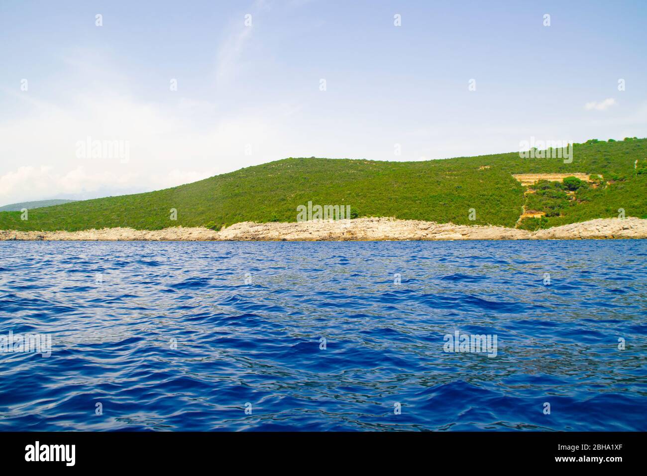 Blue sea and green hill Stock Photo - Alamy