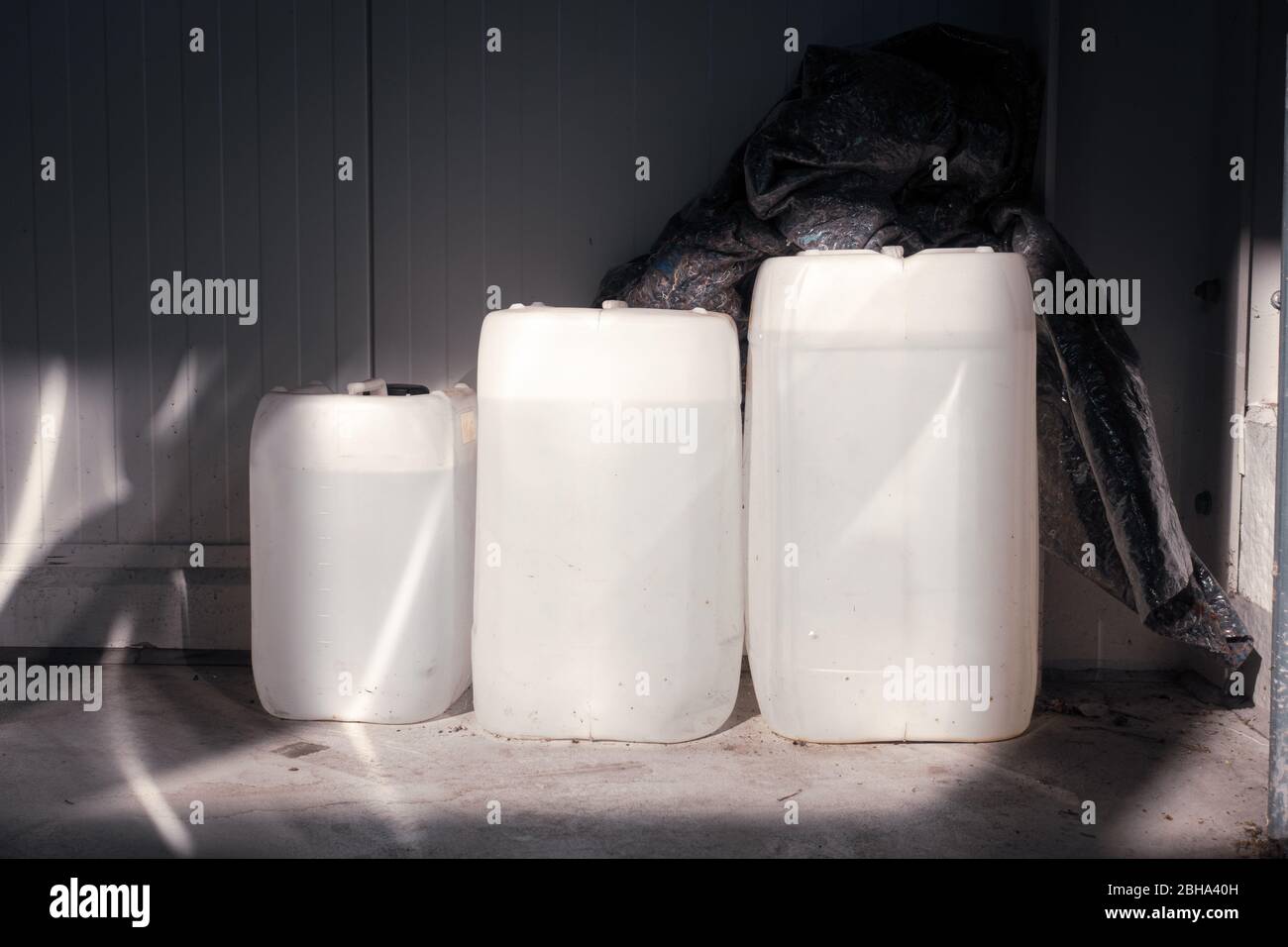 three filled white canisters of different sizes standing on a wall in a ...