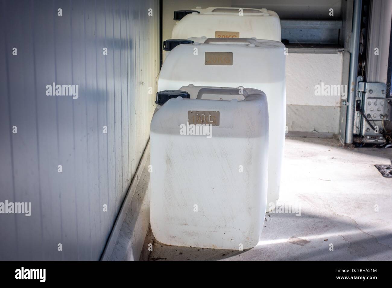 three filled white canisters of different sizes standing on a wall in a ...