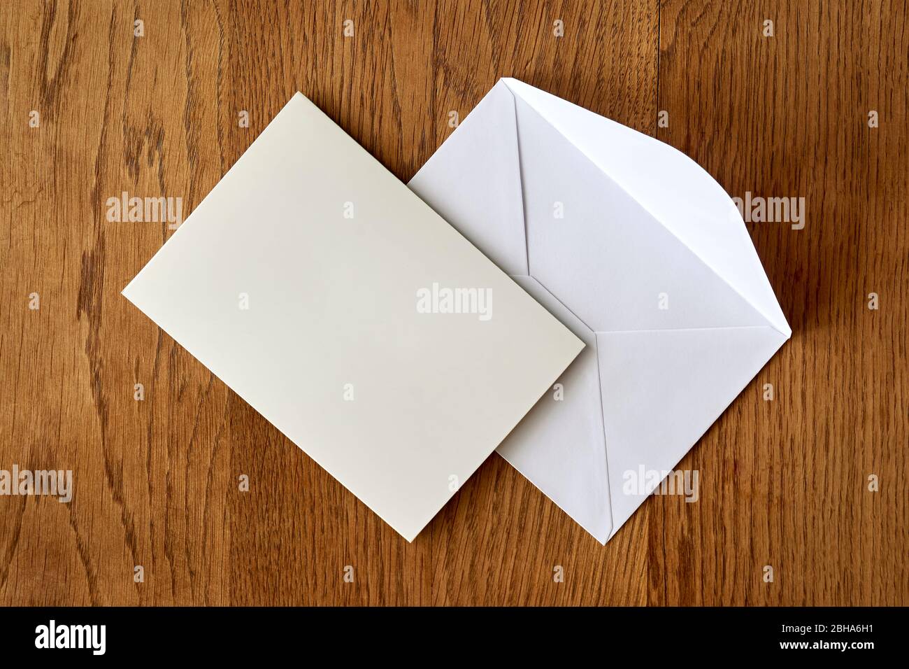Blank empty greeting card with open envelope mock up on dark wooden ...