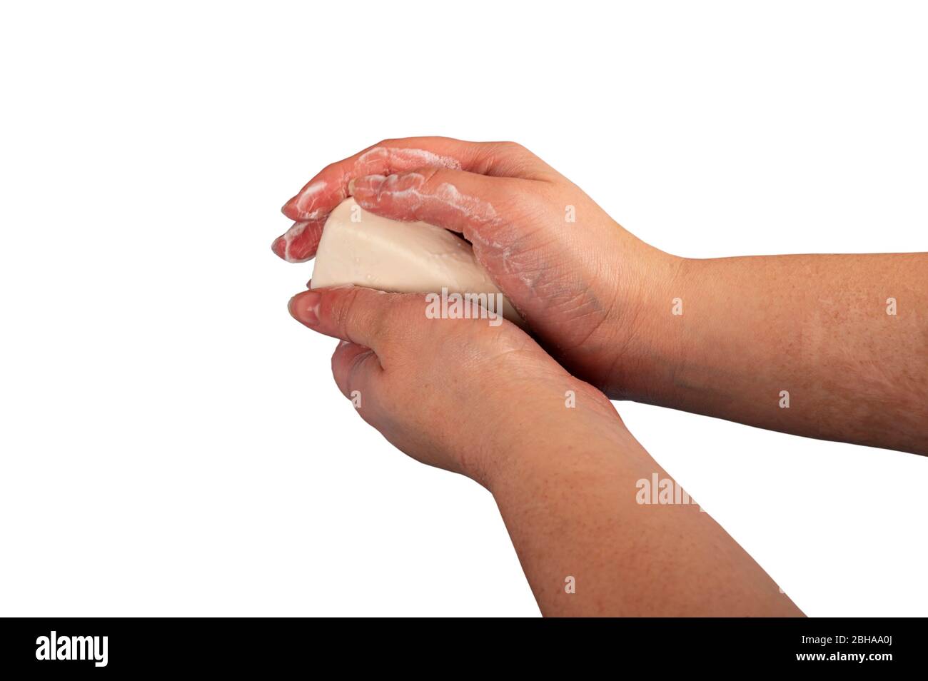 Someone is soaping their hands with a piece of toilet soap. Close up ...