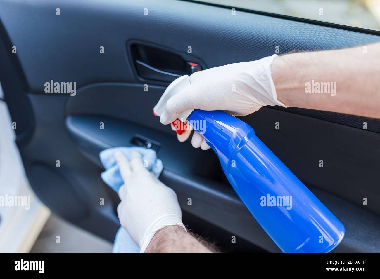 Cleansing car interior and spraying with disinfection liquid. Hands in ...