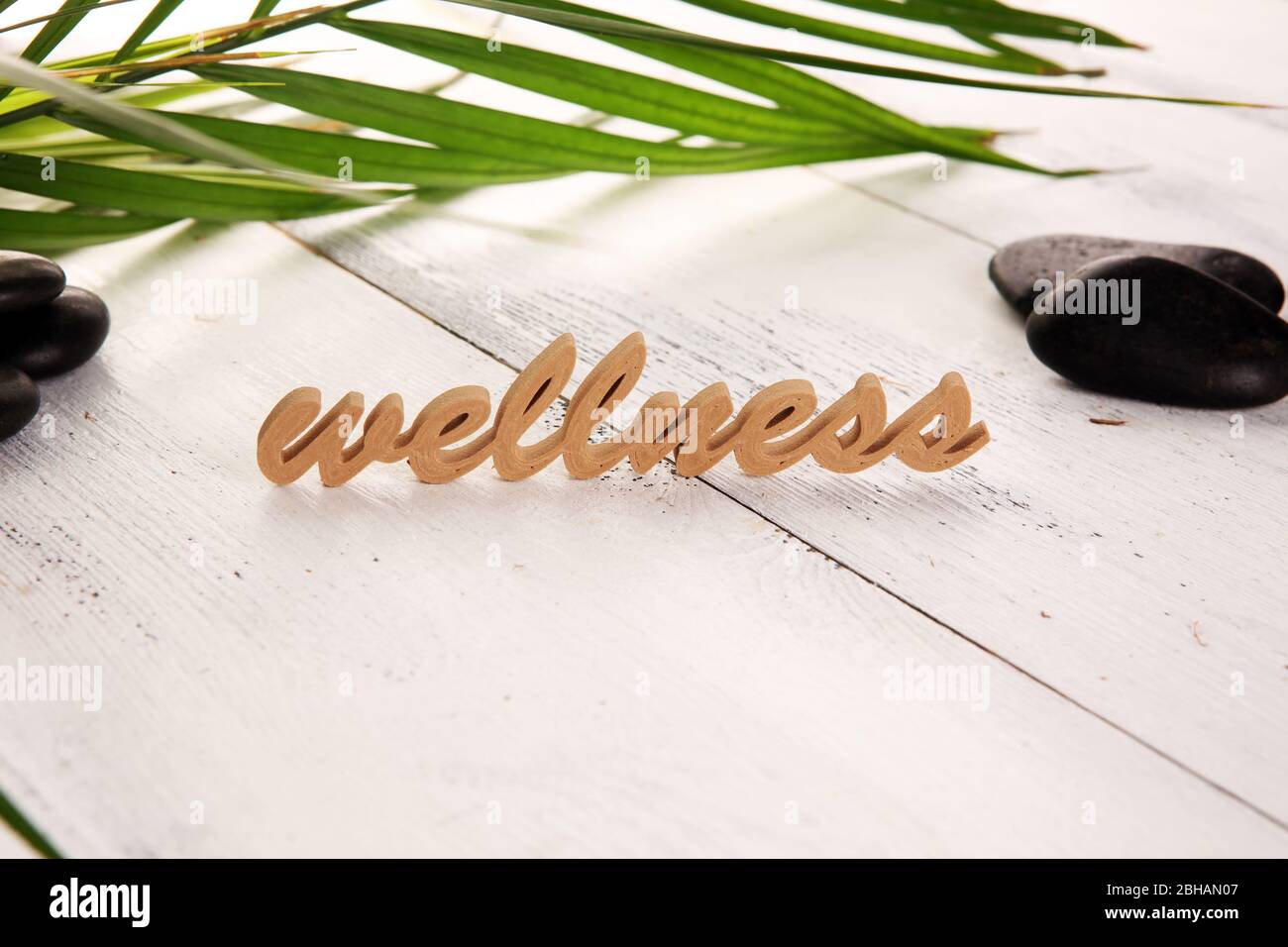 Wellness sign with wooden letters with leaves and stones. Relax therapy ...