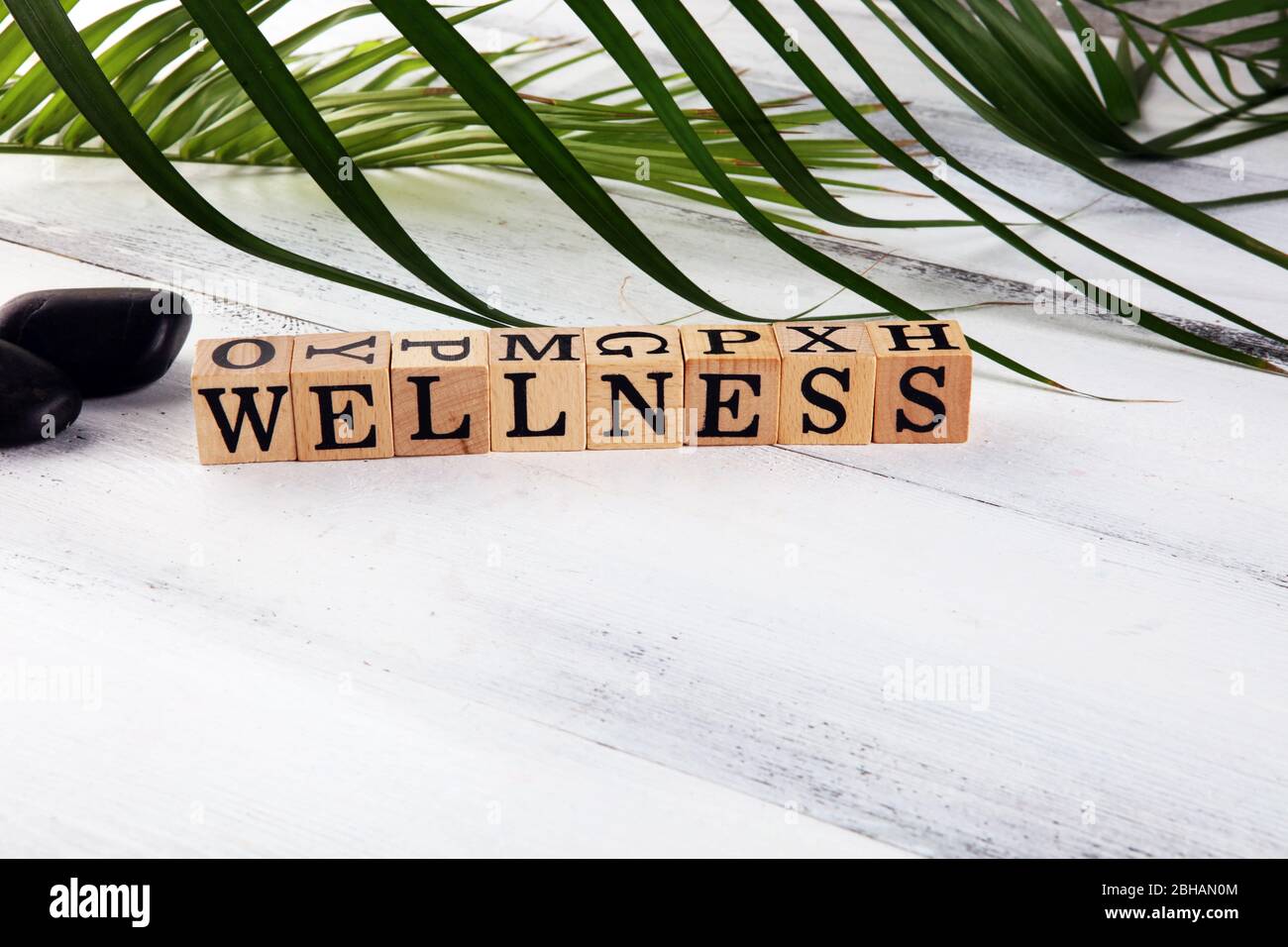 Wellness sign with wooden cubes with leaves and stones. Relax therapy ...