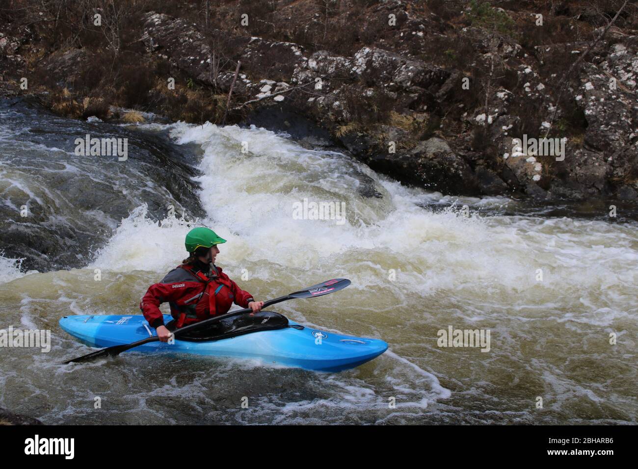 Woman white water kayaking on the river Garry, a tributary of the River ...