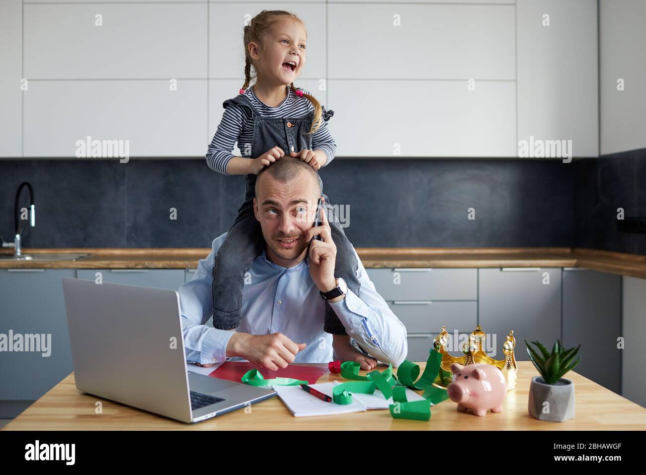 Father Working from home on laptop during quarantine. Little child girl ...