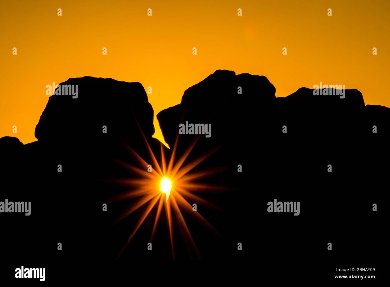 Setting sun seen through crack in rocks, Namibia Stock Photo - Alamy